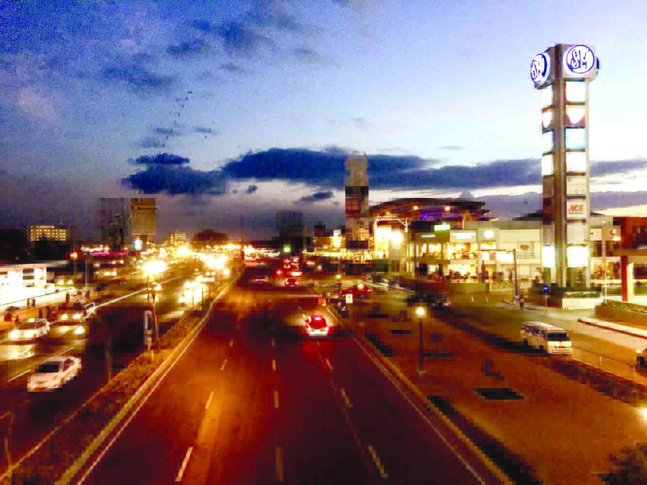 At dusk, lights illuminate along Benigno Aquino Avenue in Iloilo City.