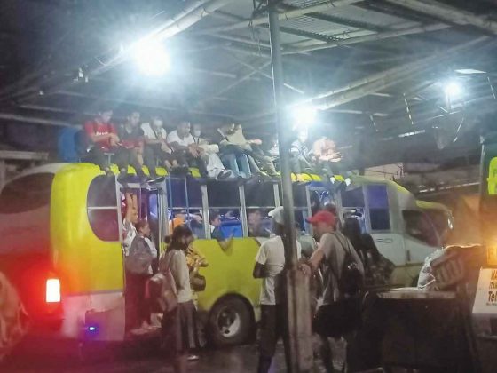 Vallacar Transit statement on yellow bus with passengers seated on the roof